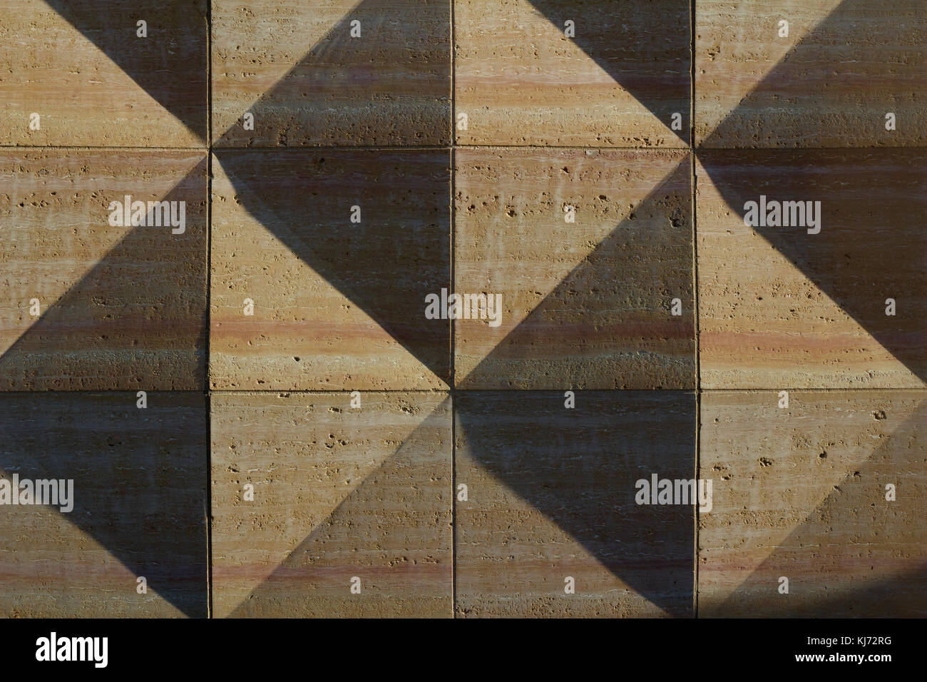 Geometric patterned concrete wall has diamond shapes accented with ...