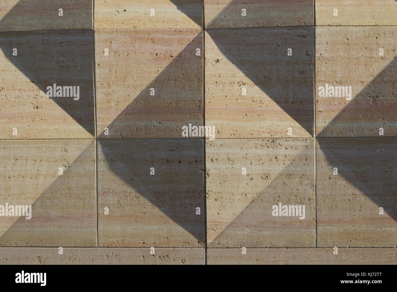 Geometric patterned concrete wall has diamond shapes accented with ...