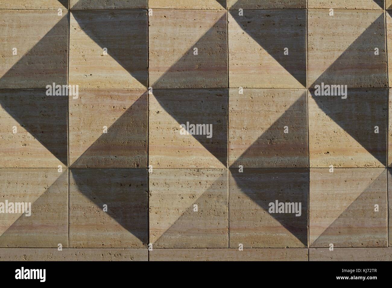 Geometric patterned concrete wall has diamond shapes accented with ...