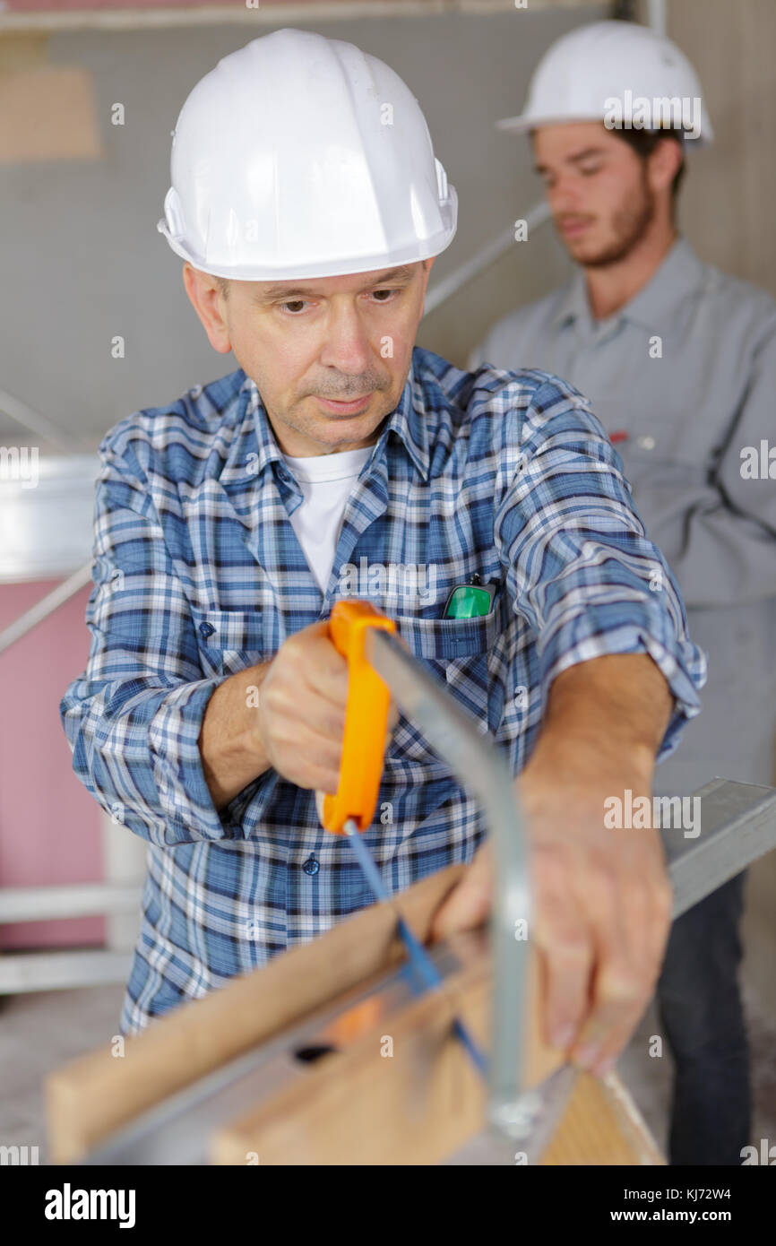 senior tradesman using hacksaw Stock Photo - Alamy