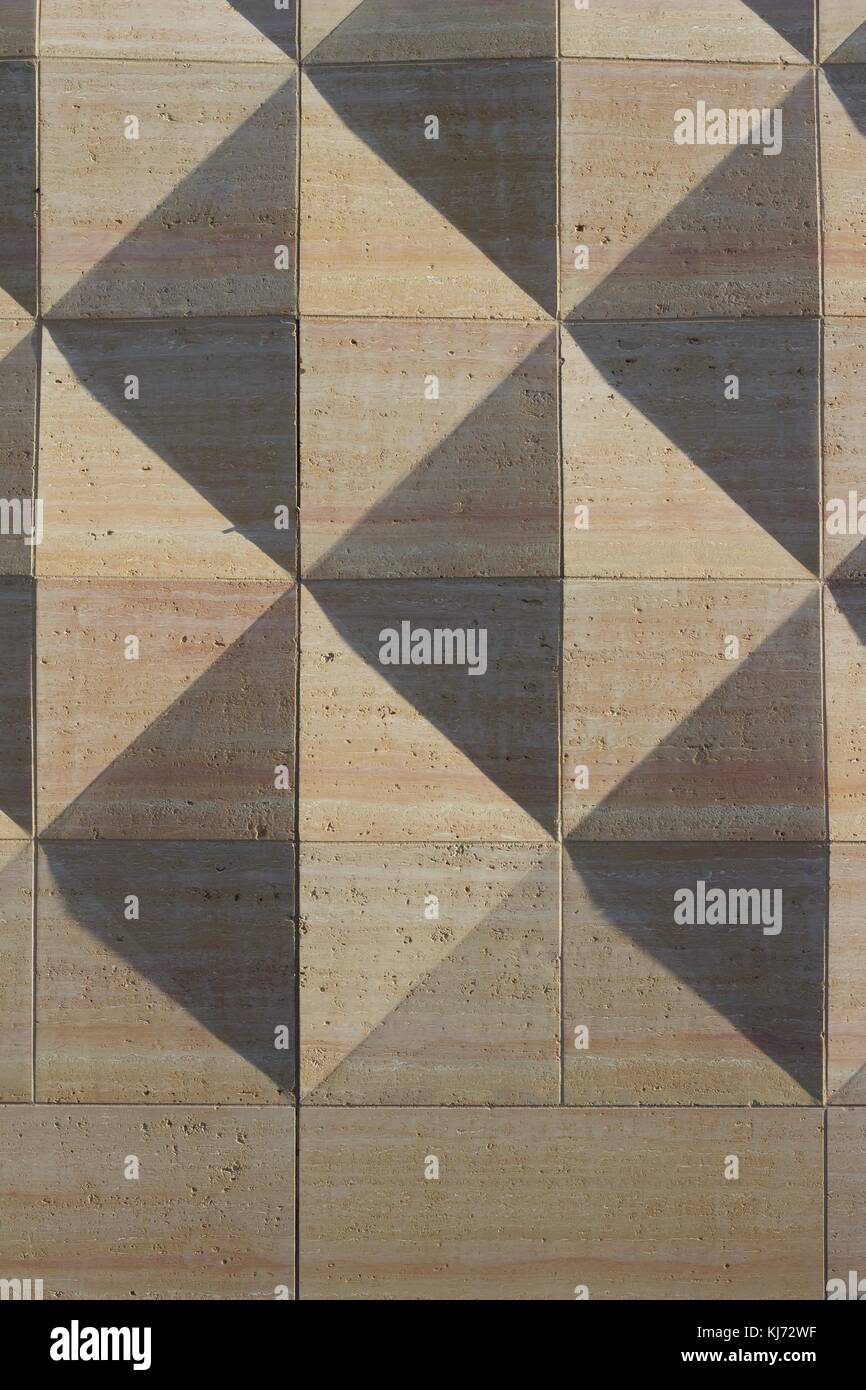 Geometric patterned concrete wall has diamond shapes accented with ...