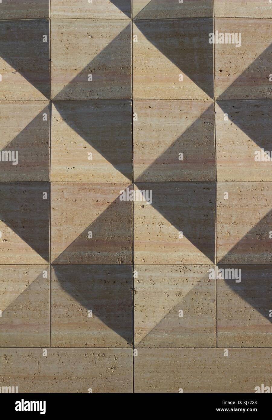 Geometric patterned concrete wall has diamond shapes accented with ...