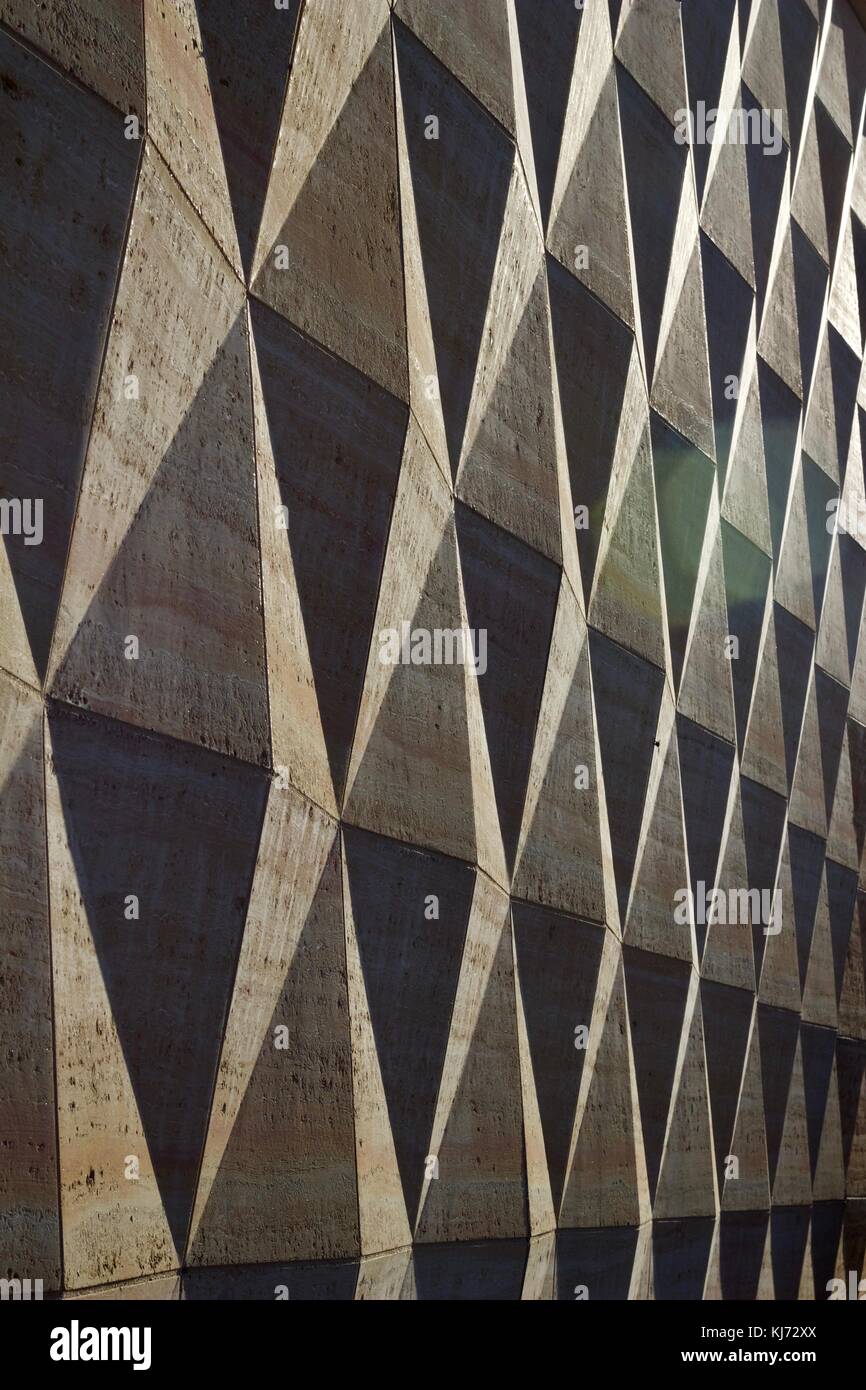 Geometric patterned concrete wall has diamond shapes accented with ...