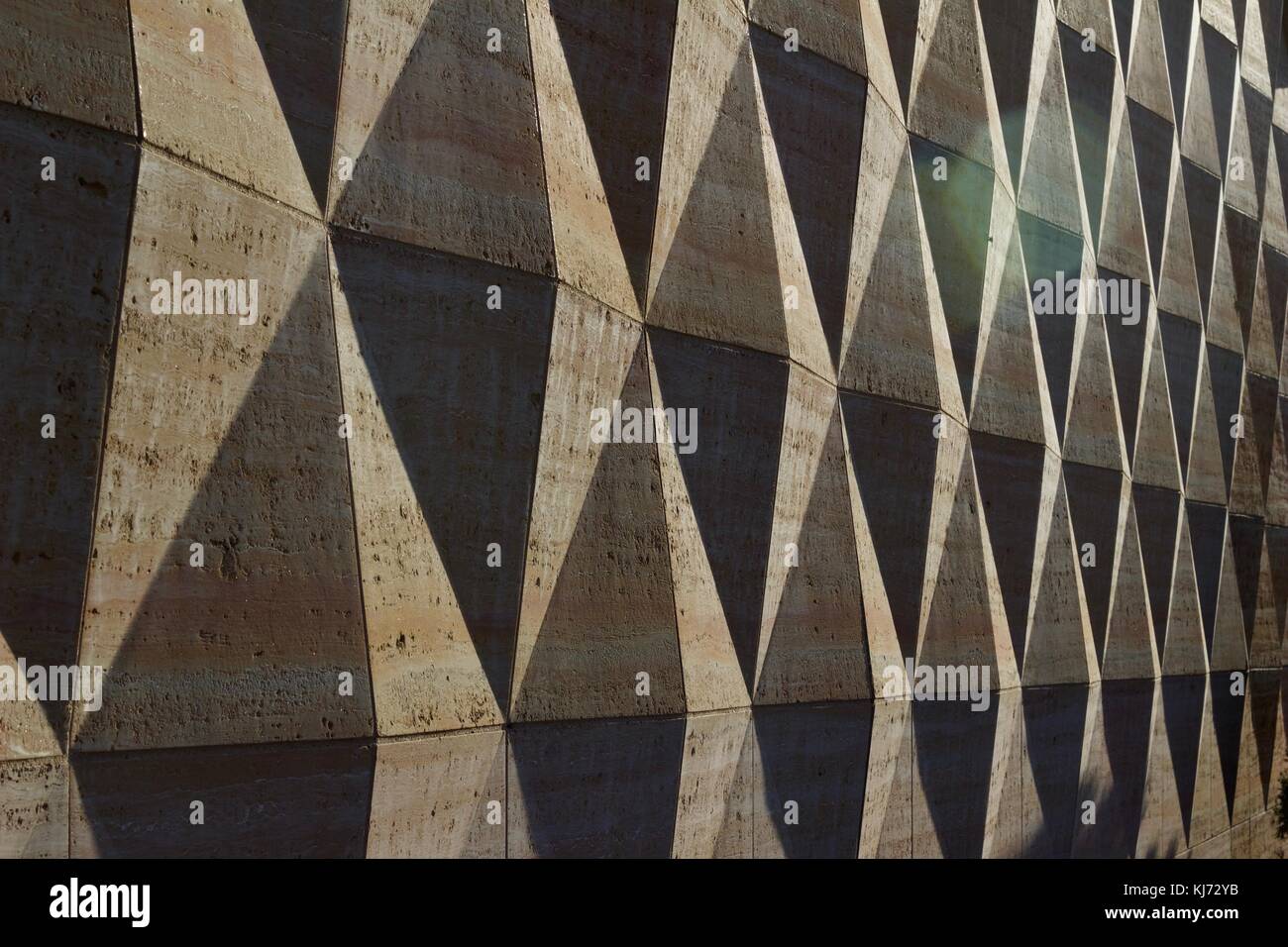 Geometric patterned concrete wall has diamond shapes accented with ...
