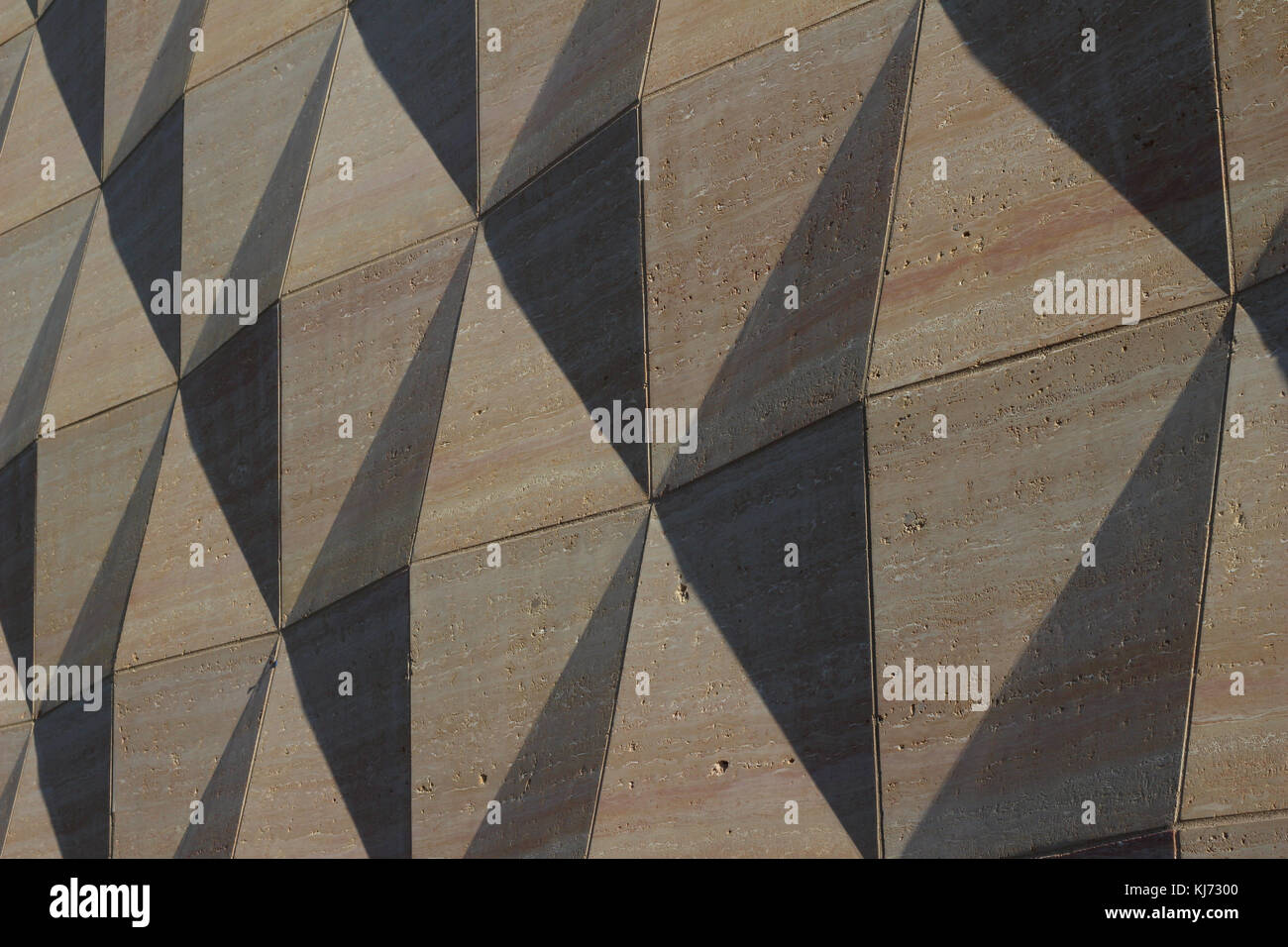 Geometric patterned concrete wall has diamond shapes accented with ...