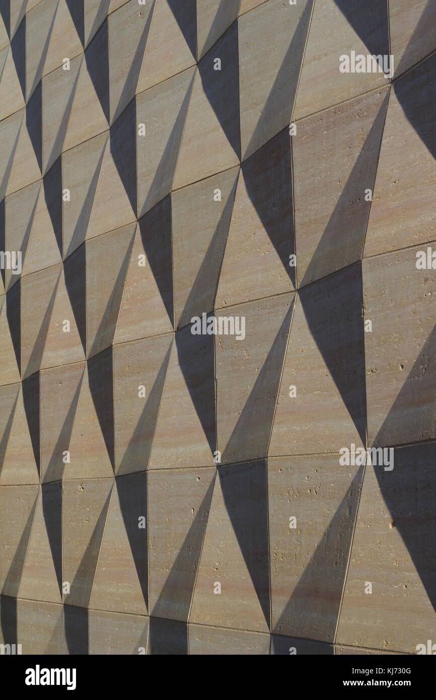 Geometric patterned concrete wall has diamond shapes accented with ...
