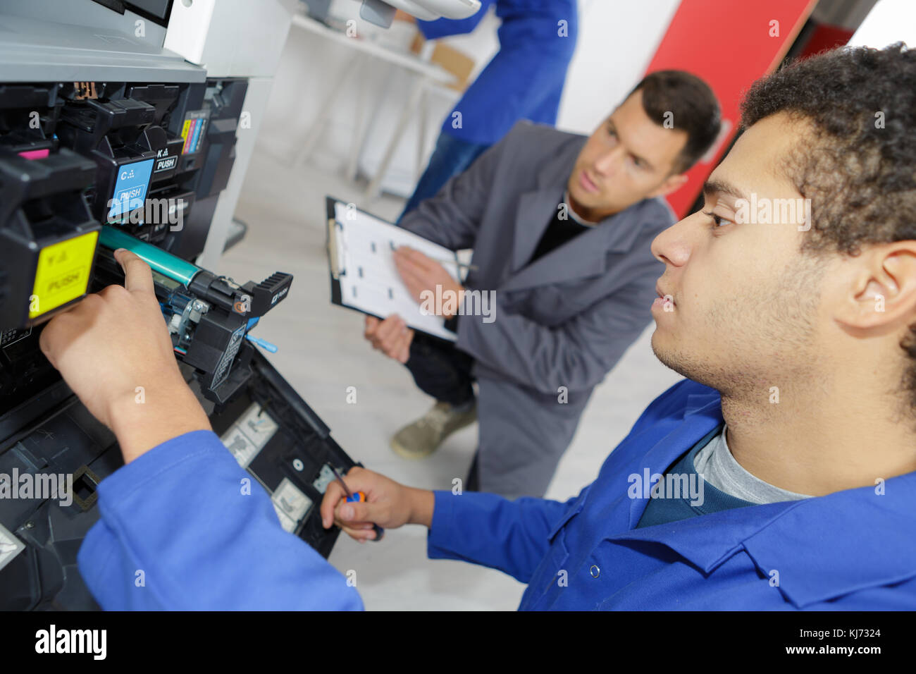 young male technician repairing digital photocopier machine Stock Photo ...