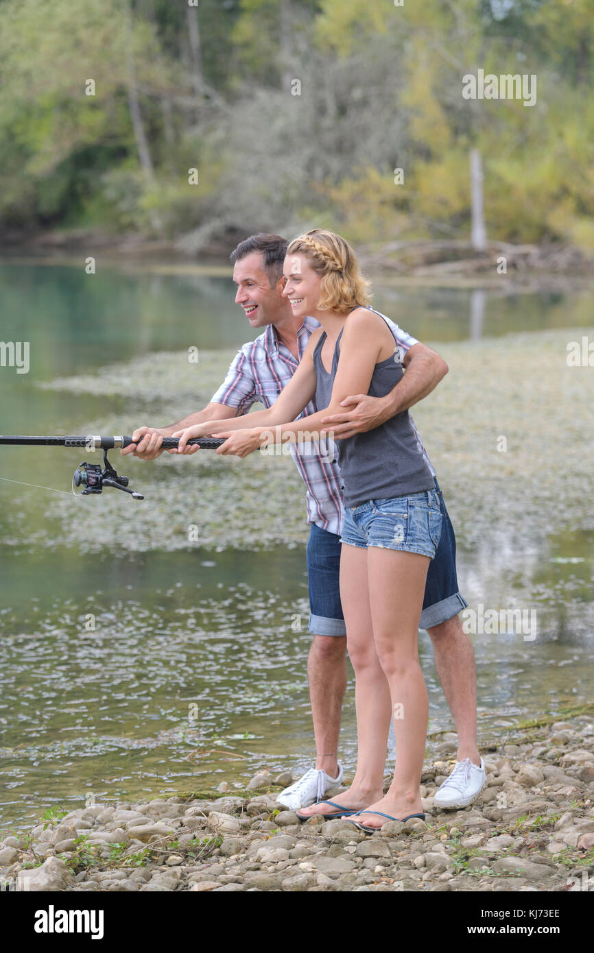 lovely young couple fishing together by a lake Stock Photo - Alamy
