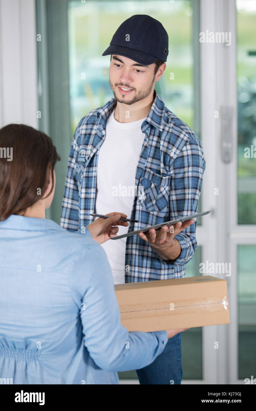 woman getting a parcel from delivery man Stock Photo - Alamy