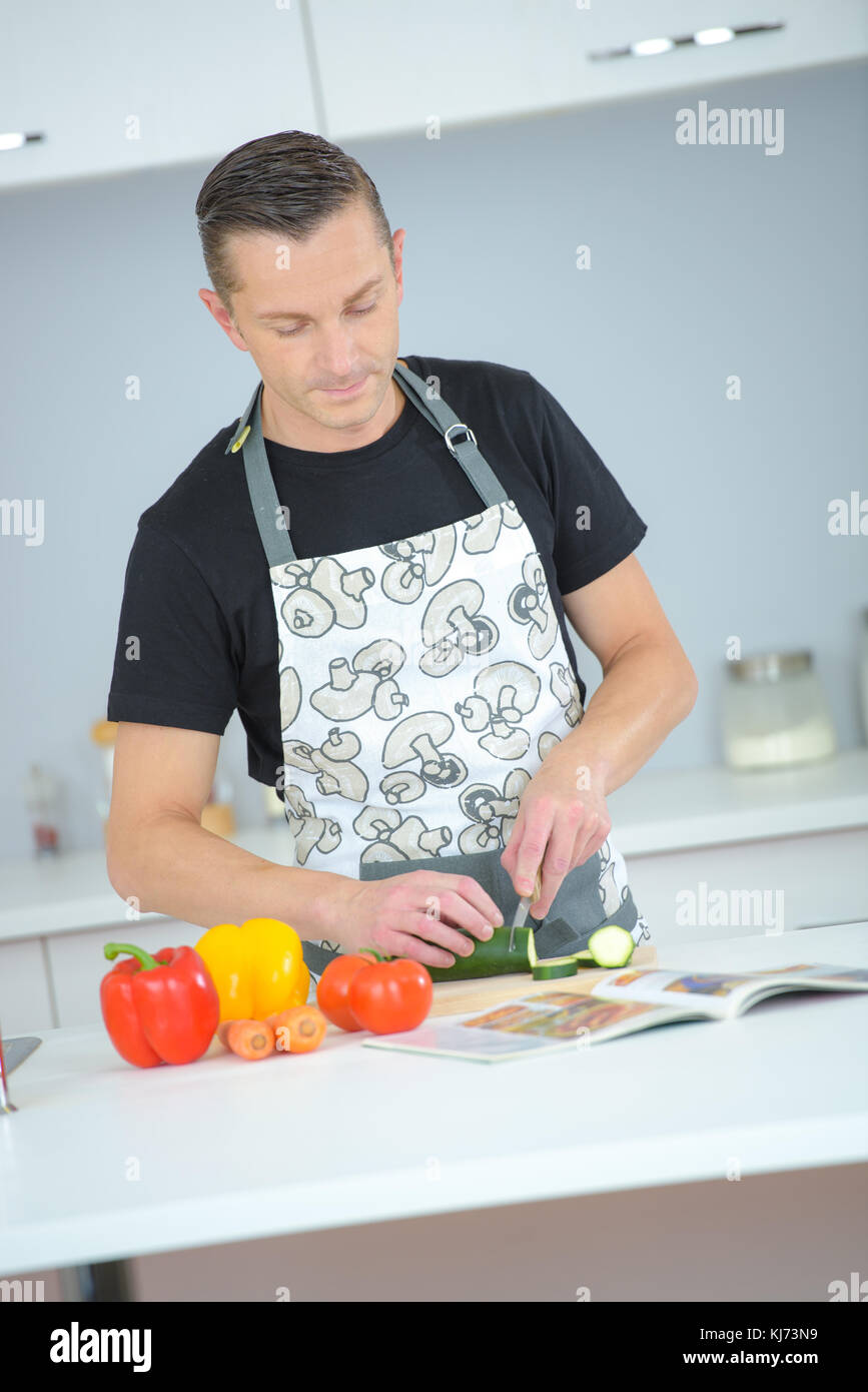 husband cooking dinner from recipe book Stock Photo - Alamy