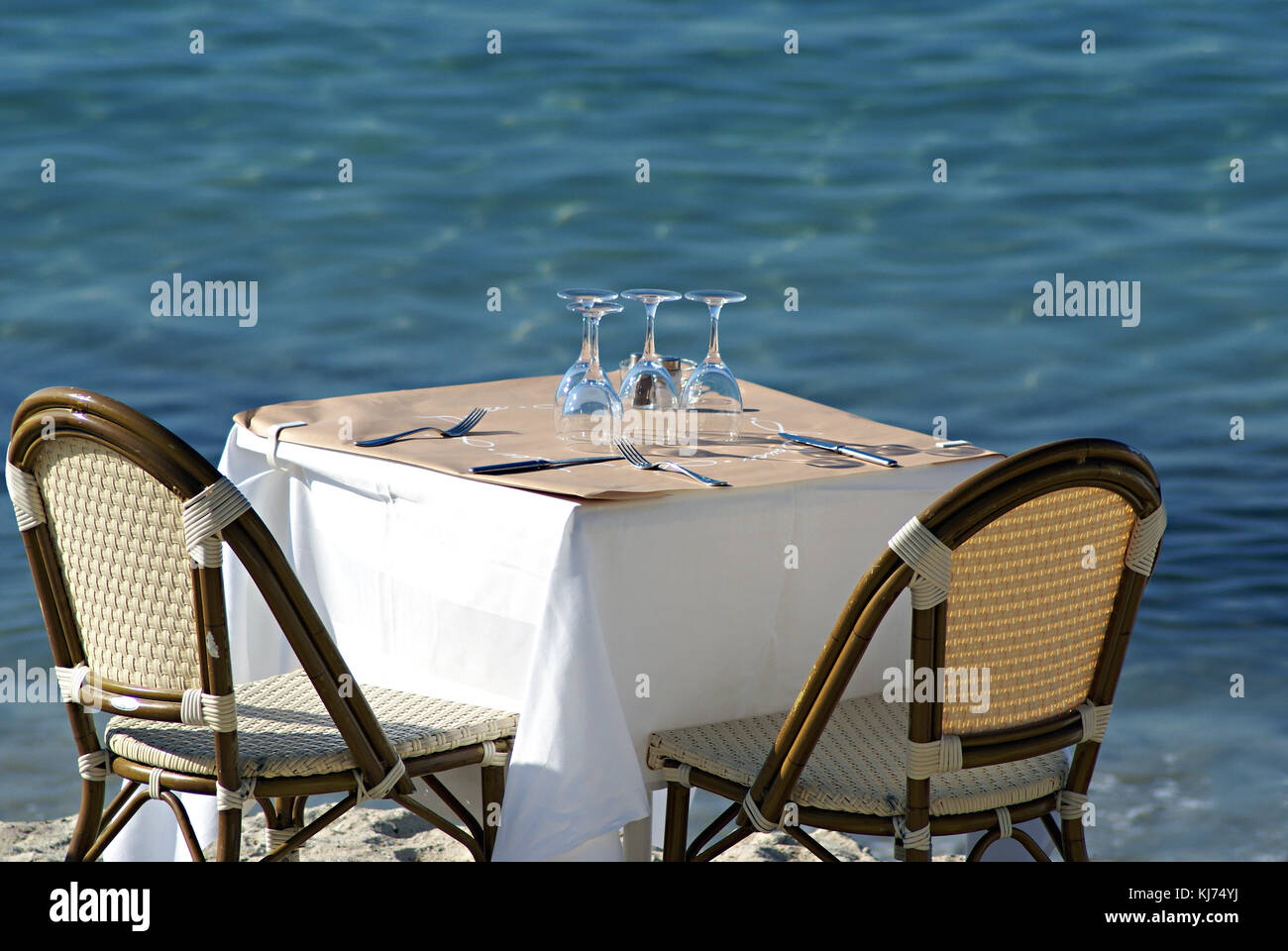 Restaurant table for two, at the edge of the water, facing the sea ...
