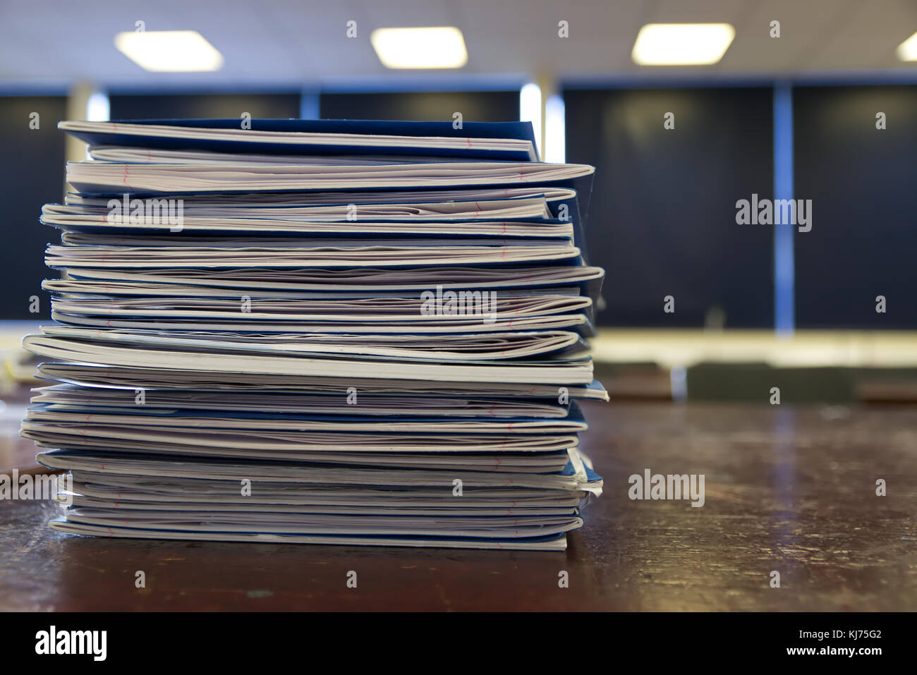Pile of student notebooks in a school classroom on an old wooden desk ...
