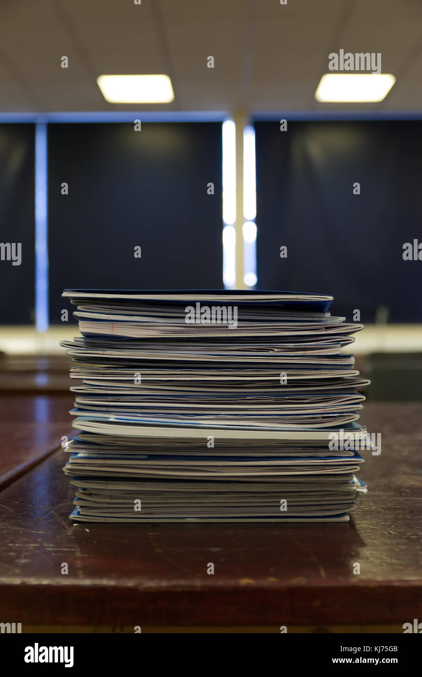 Pile of student notebooks in a school classroom on an old wooden desk ...