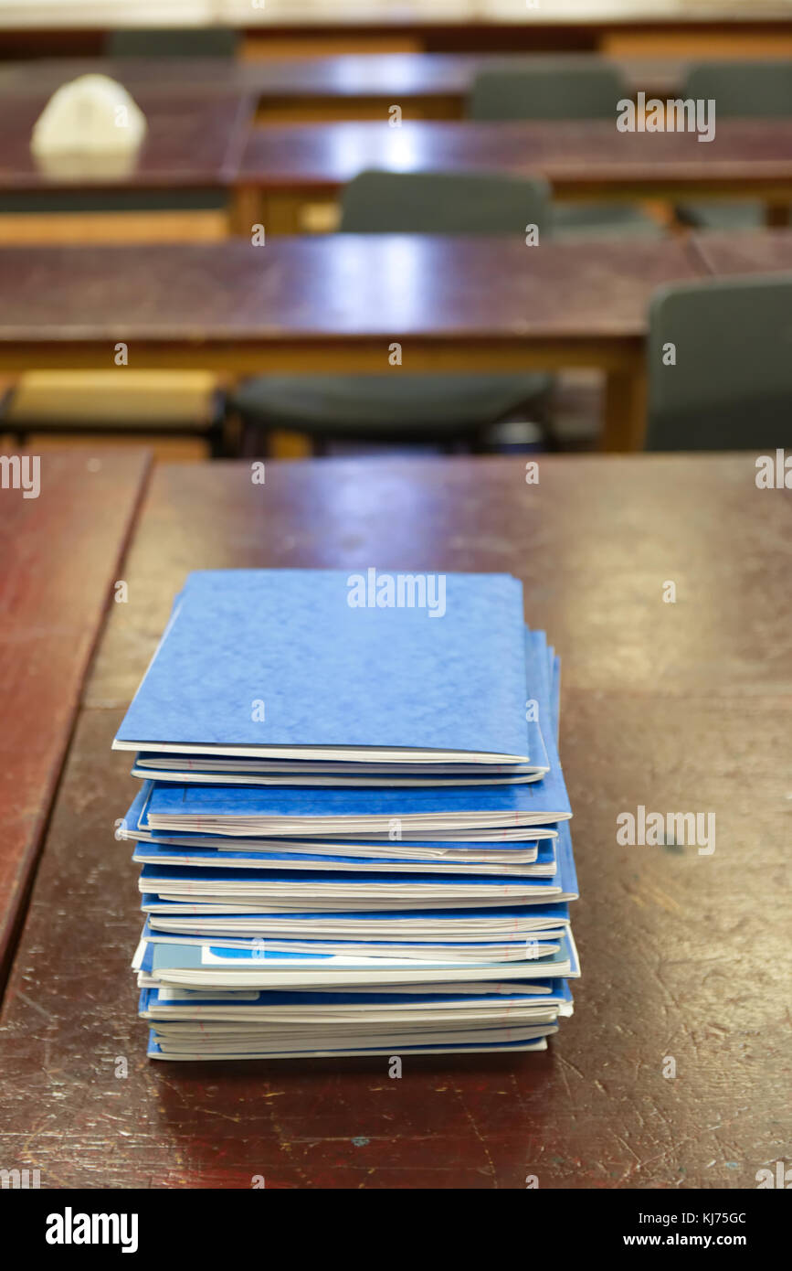 Pile of student notebooks in a school classroom on an old wooden desk ...