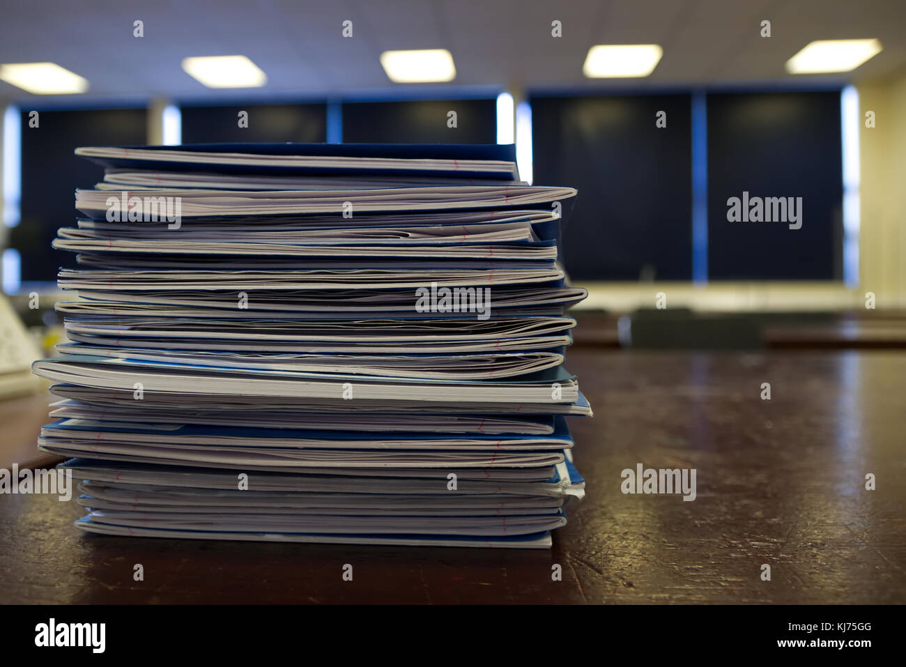 Pile of student notebooks in a school classroom on an old wooden desk ...