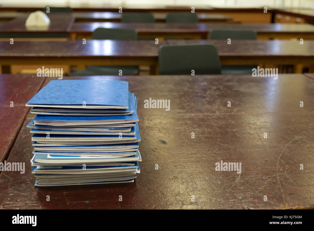 Pile of student notebooks in a school classroom on an old wooden desk ...