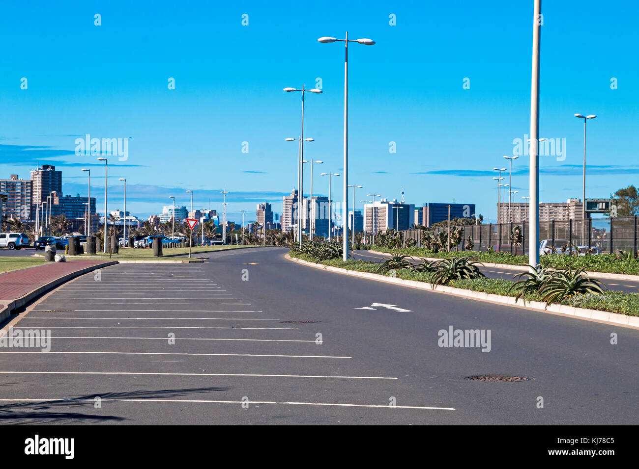 Empty parking bays on beachfront road heading towards Durban city blue ...