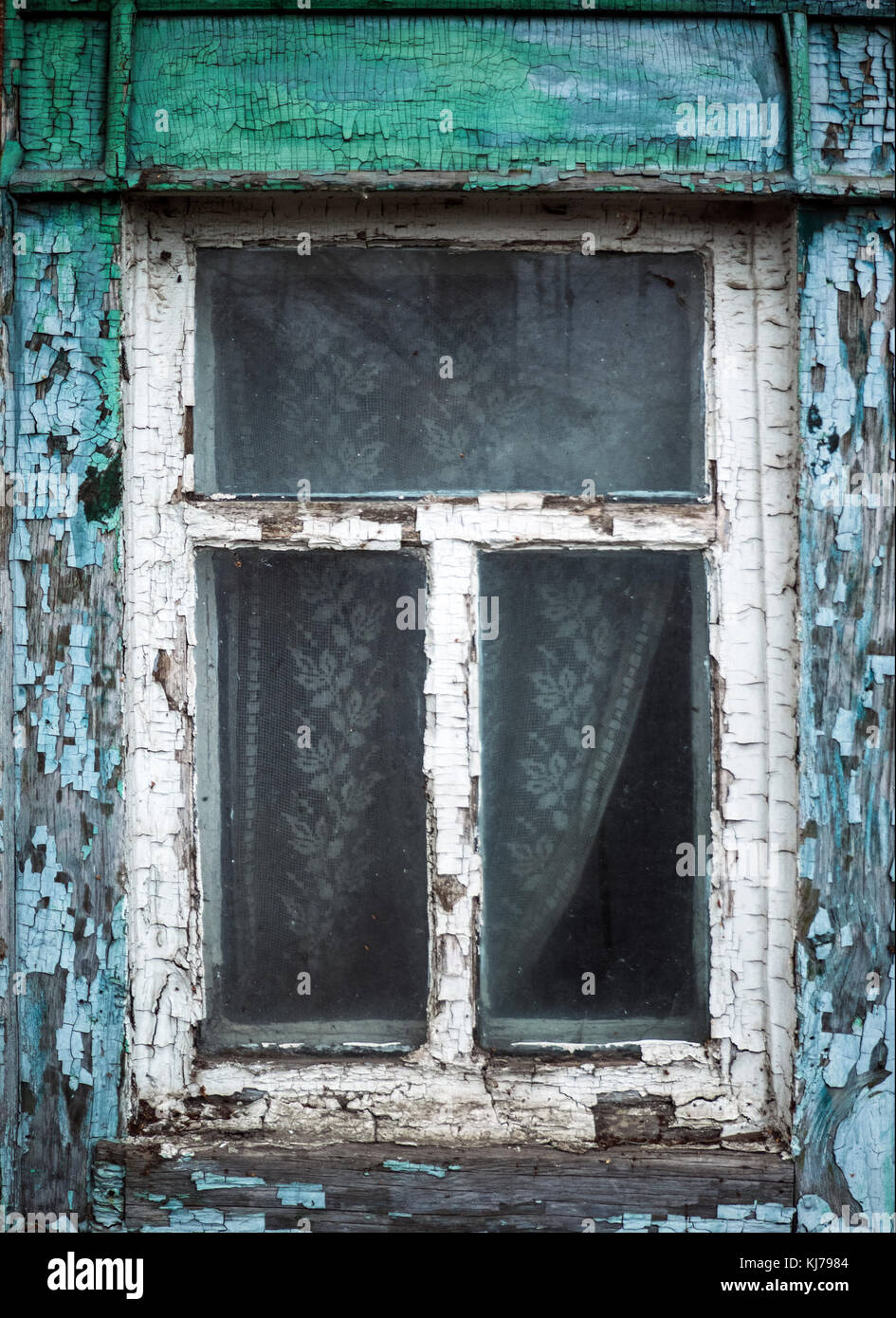 old wooden window with shabby paint and dusty glass in an abandoned ...