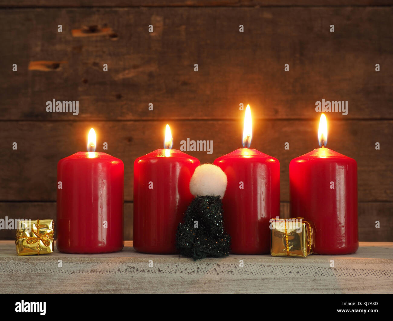 Four red Advent candles on a rustic wooden background, all candles ...