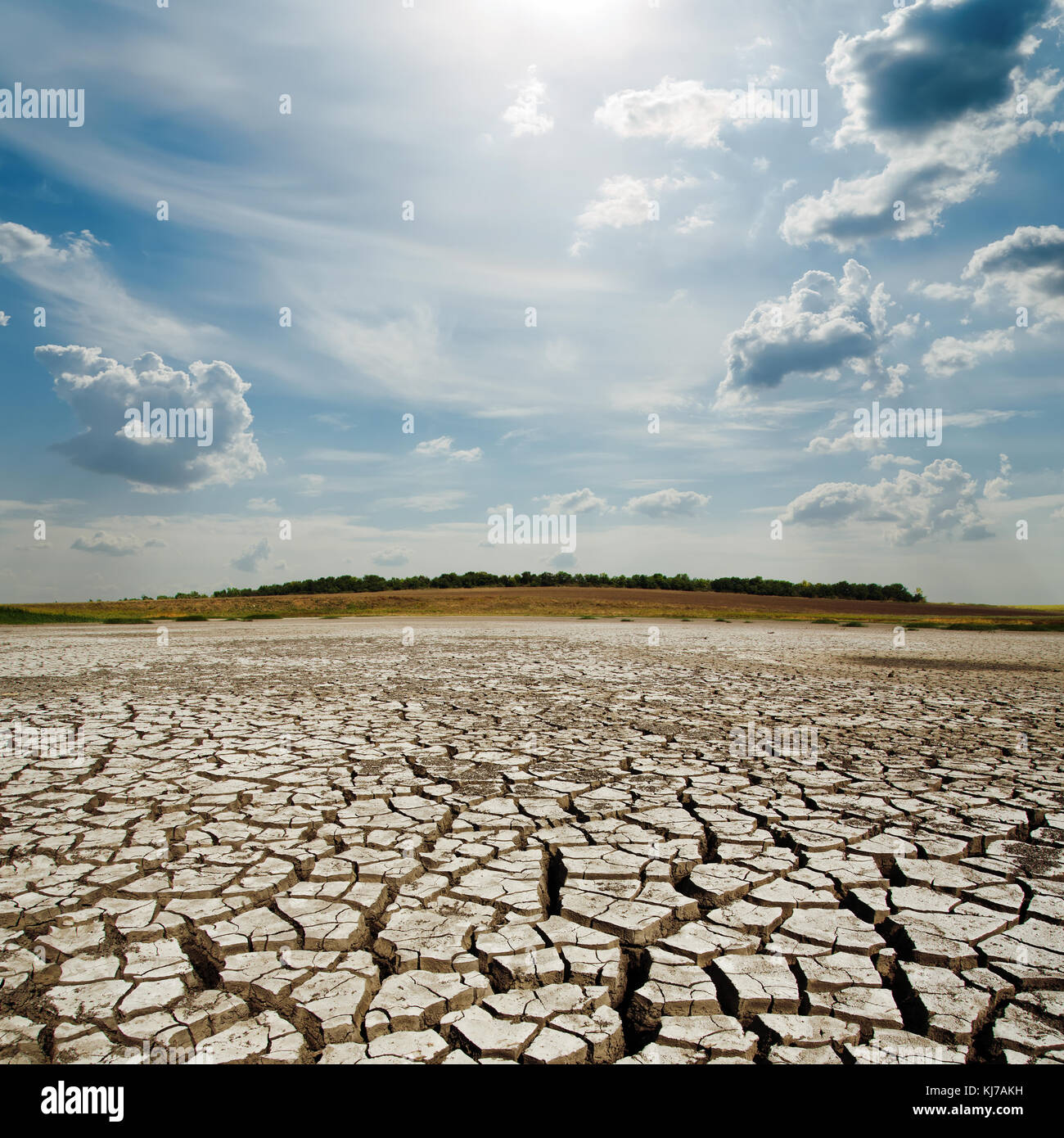 dramatic clouds with sun over drought earth Stock Photo - Alamy