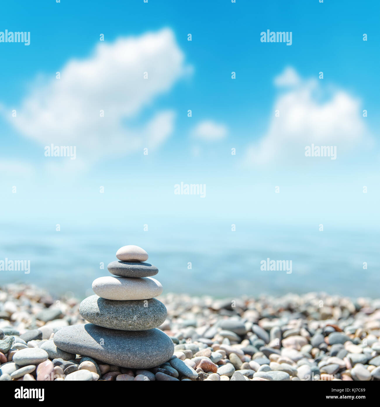 stack of rounded stones zen-like and blue sky with clouds. soft focus ...