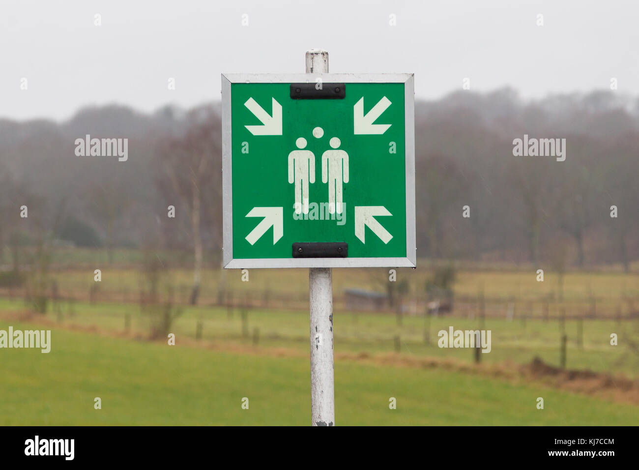 Green plastic 'assembly point' sign, dutch landscape in the background ...