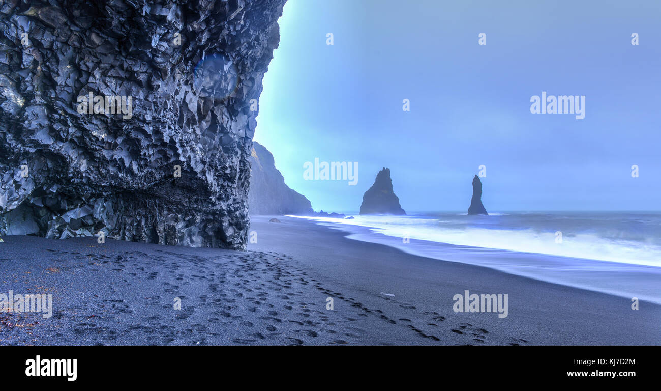 Wide view of Reynisdrangar rock formations on Reynisfjara Beach at dusk ...