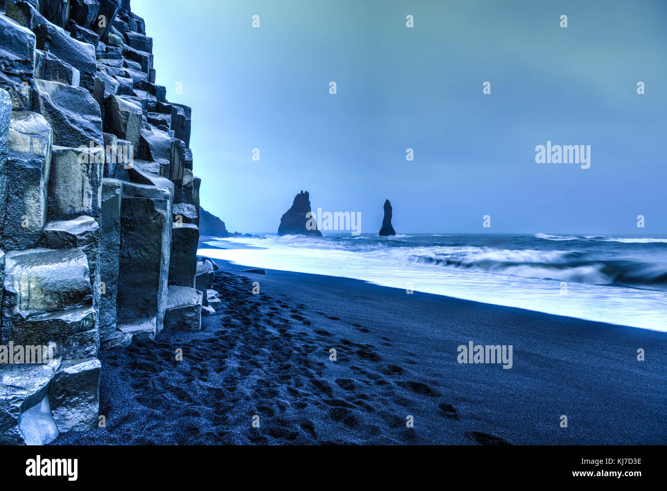 Wide view of Reynisdrangar rock formations on Reynisfjara Beach at dusk ...