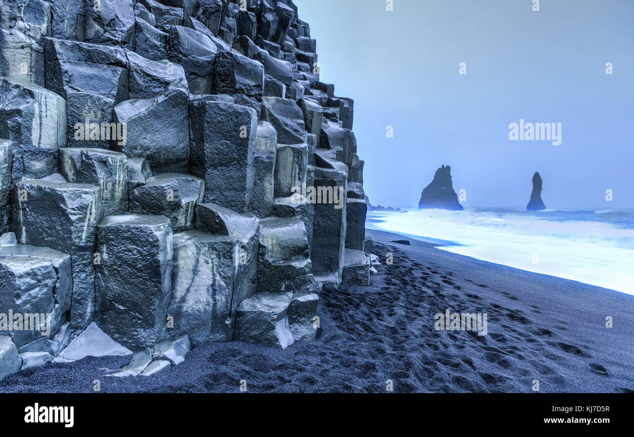 Wide view of Reynisdrangar rock formations on Reynisfjara Beach at dusk ...