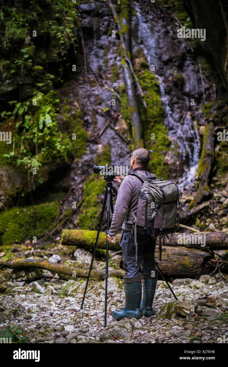 Professional photographer with cameras on tripod shooting in a river ...