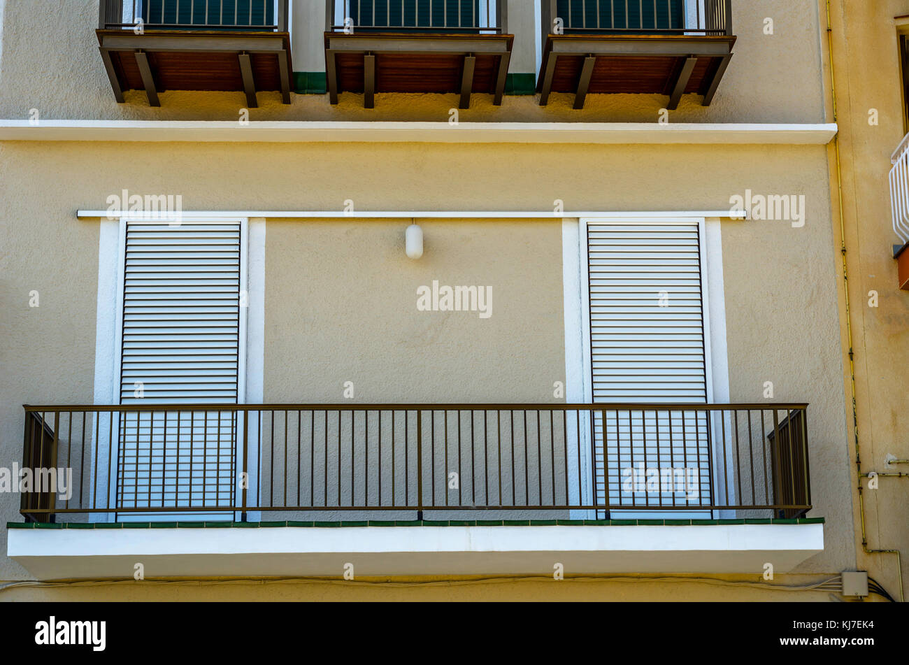 Stylish balcony with a metal railing, solid architectural element, a ...