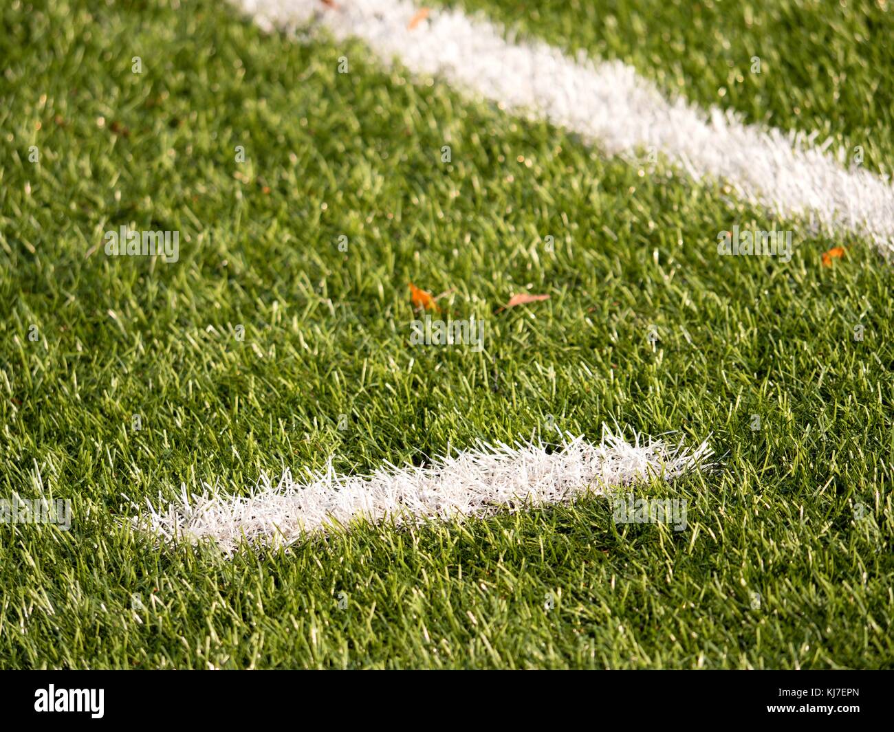 White line marks painted on artificial green turf background. Playfield ...