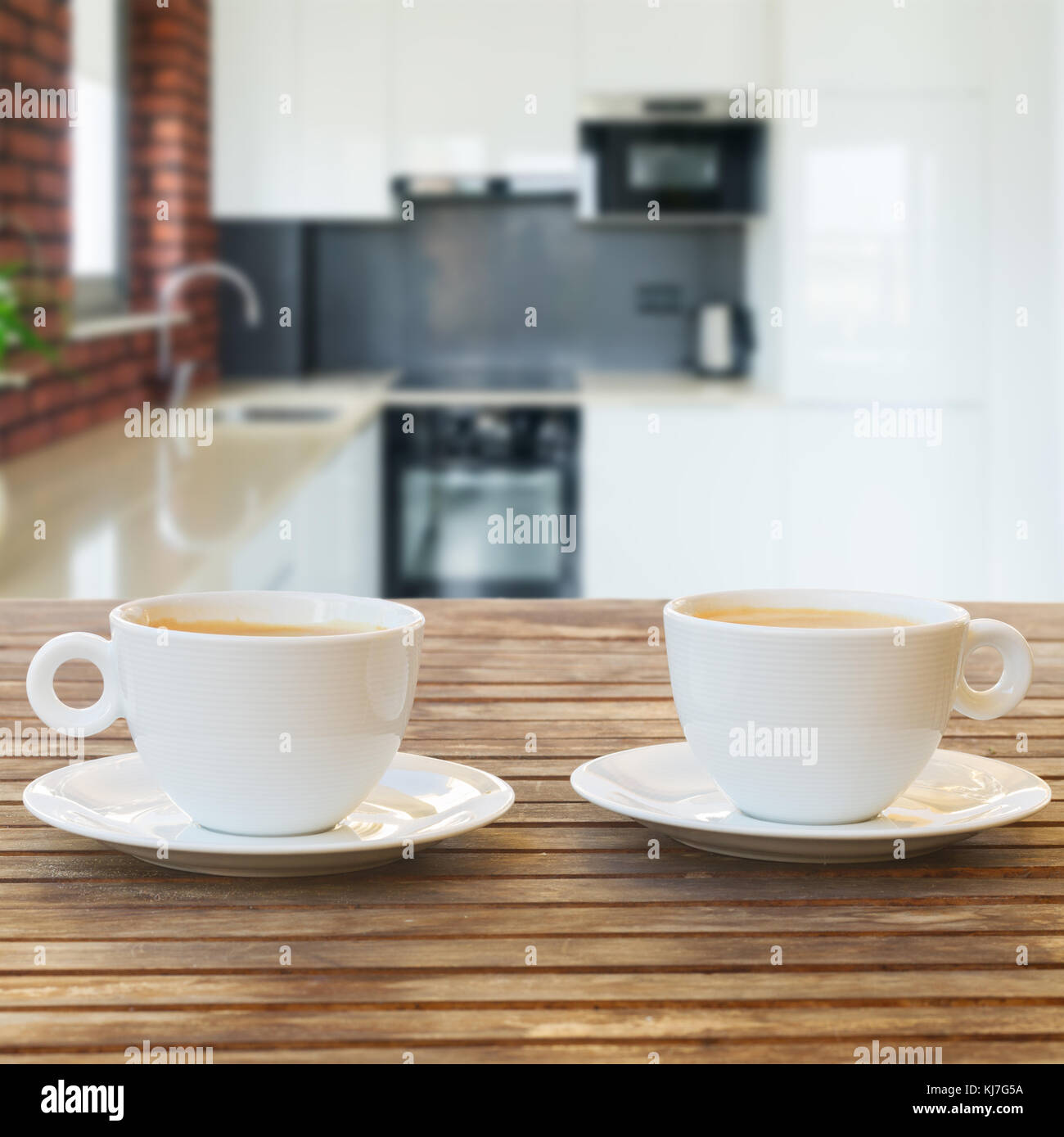 Empty kitchen wooden table top with two coffee cups, modern kitchen in ...