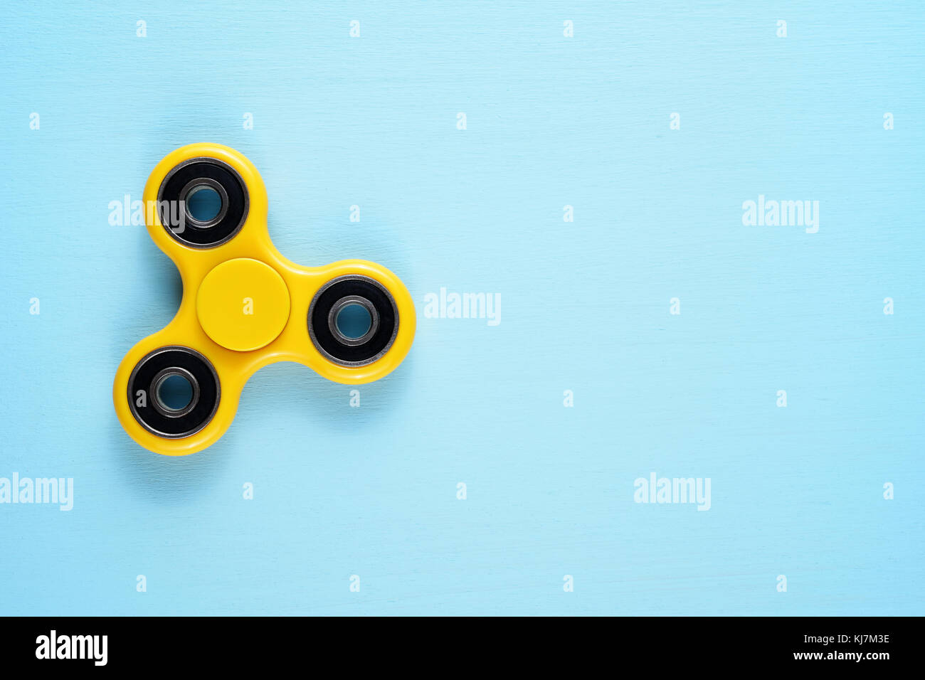 Fidget spinner toy on blue background Stock Photo - Alamy