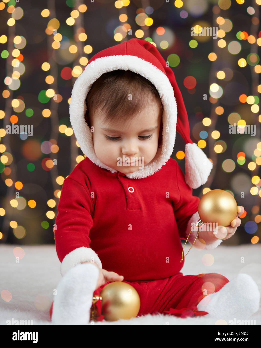 little kid boy dressed as santa playing with christmas toys, dark ...