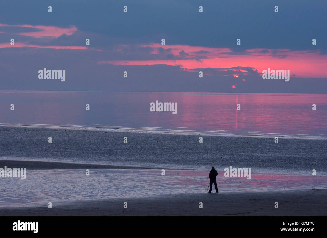 Single photographer photographing sunset over The Wash, Hunstanton ...