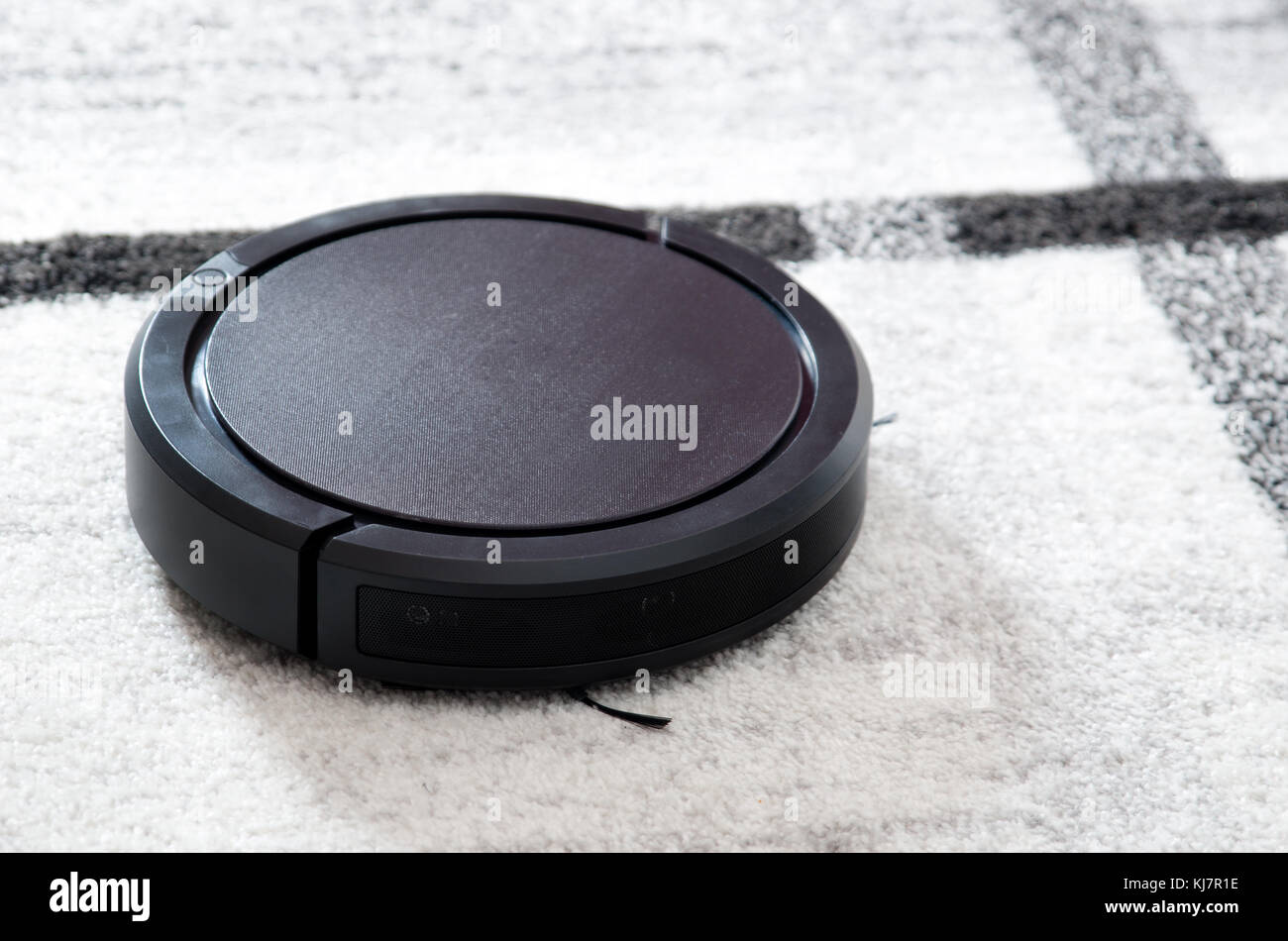Robotic vacuum cleaner working on carpet. Smart cleaning technology ...