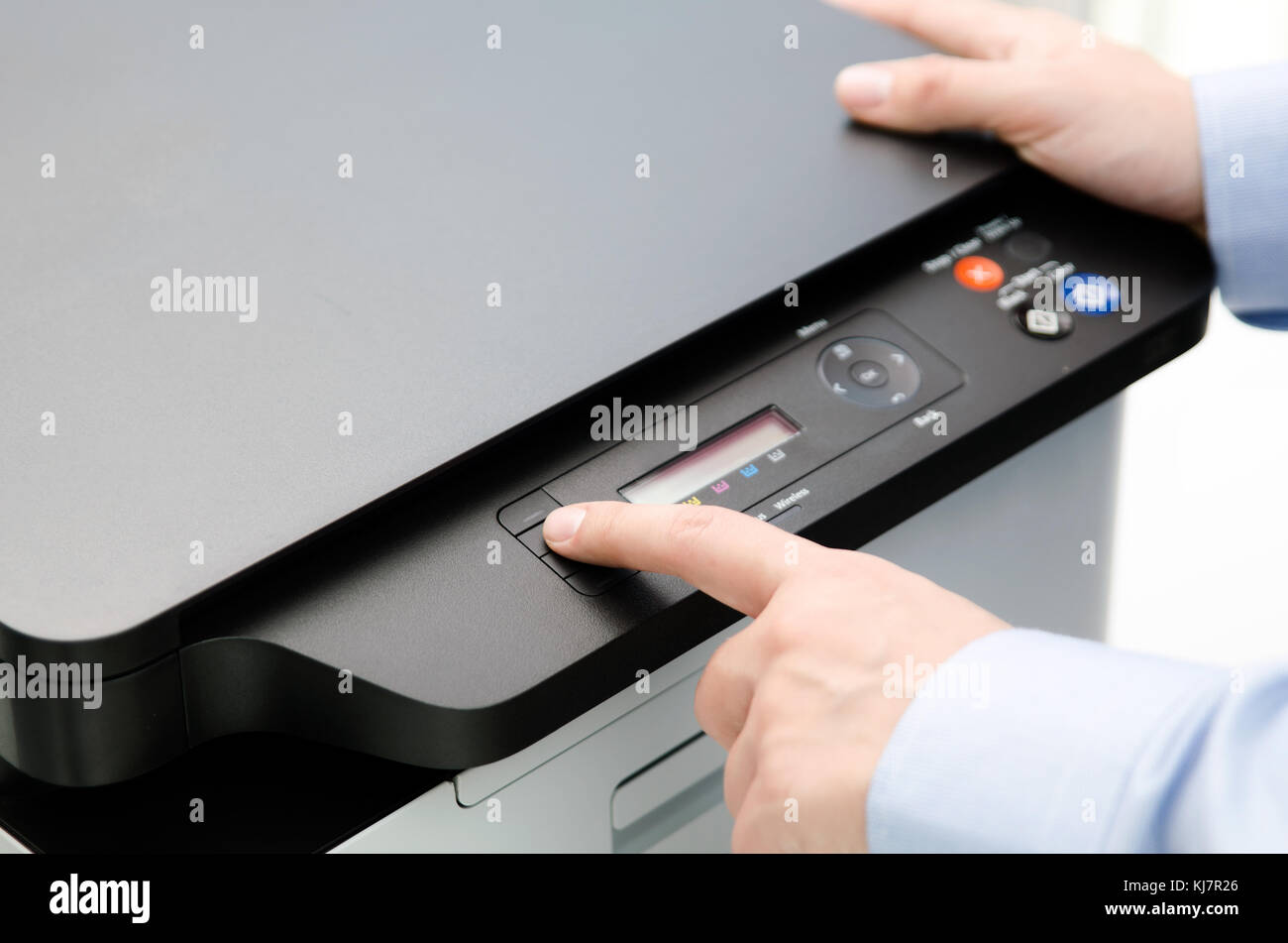 Hand press button on panel of printer. printer scanner laser office ...