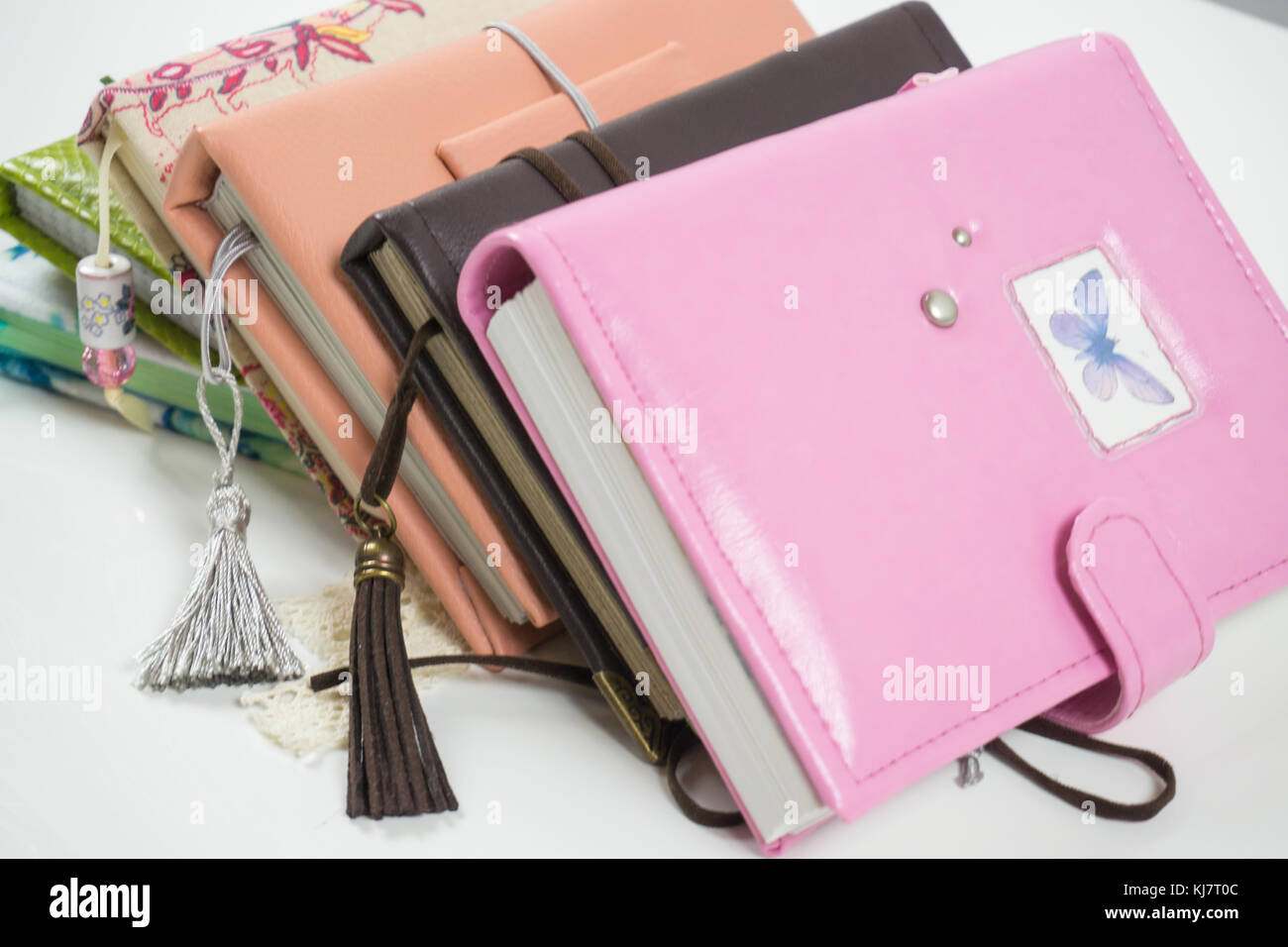 Handmade decorated notebooks and planners of different colors on white ...