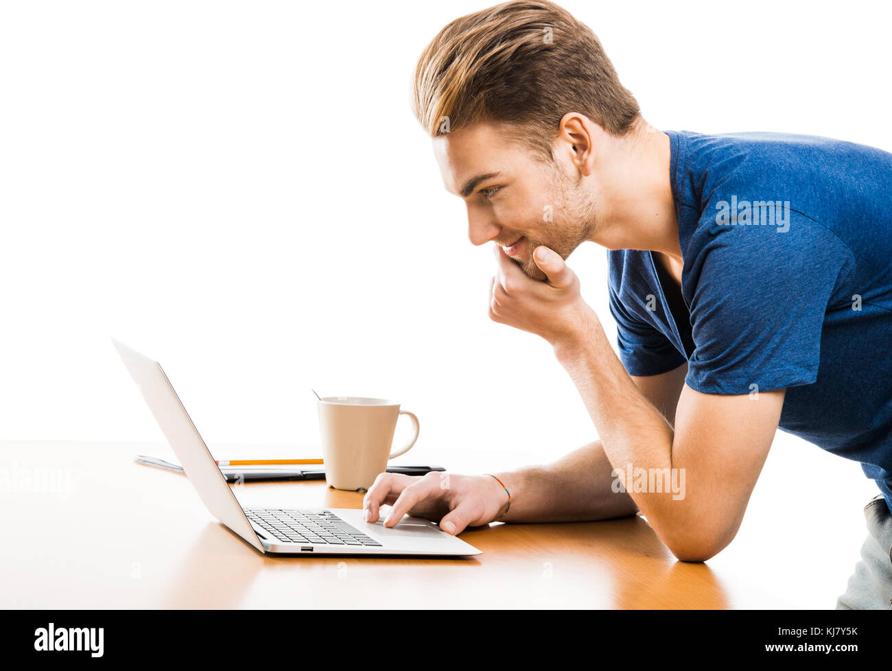 Young student sitting on the desk working with a laptop Stock Photo - Alamy