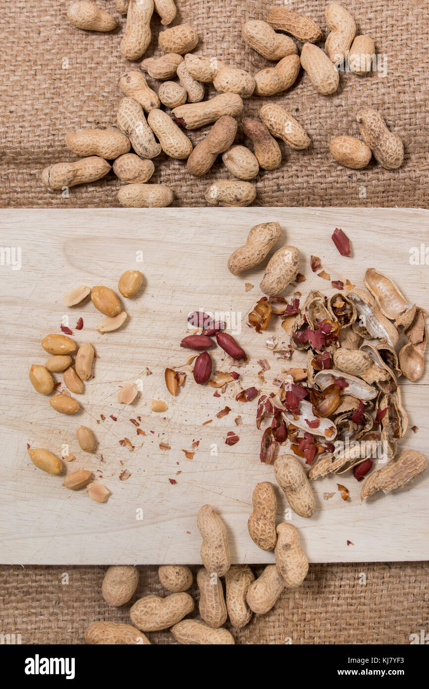 peanuts cracked and opened over a wooden board Stock Photo - Alamy