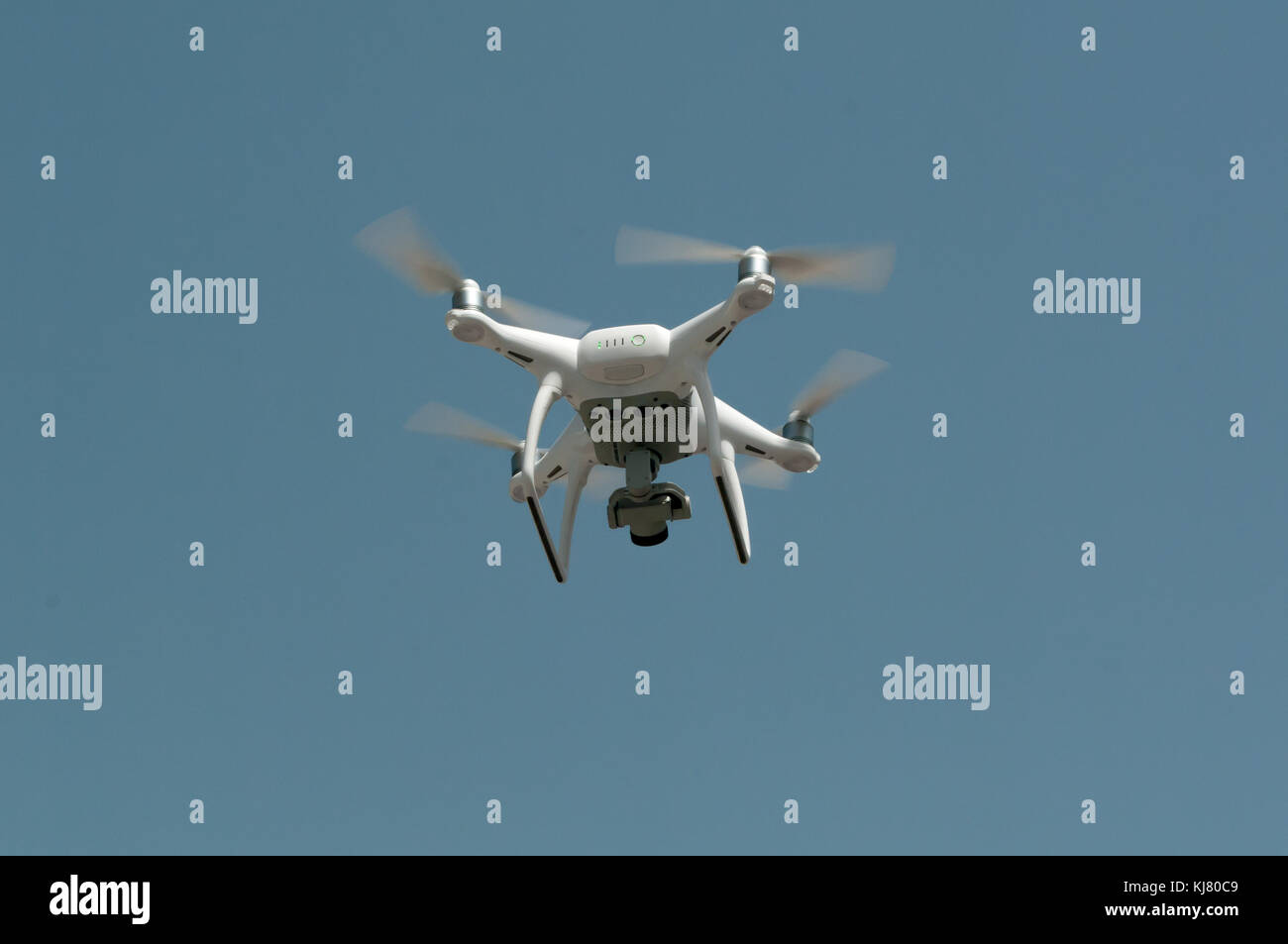 White drone in the sky. Flying quadrocopter drone in the sky with ...
