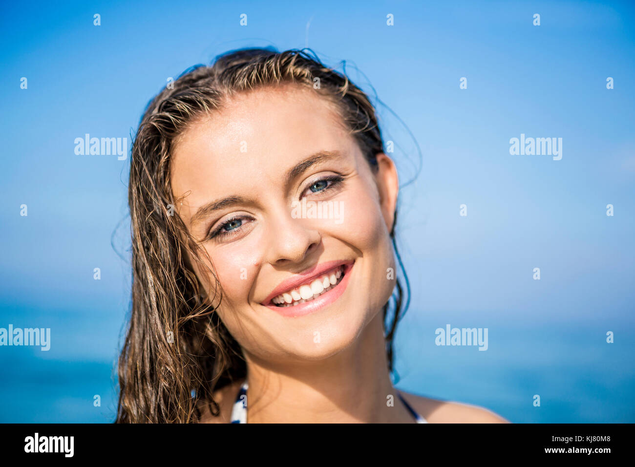 Outdoor portrait of a beautiful young woman with the ocean in the back ...