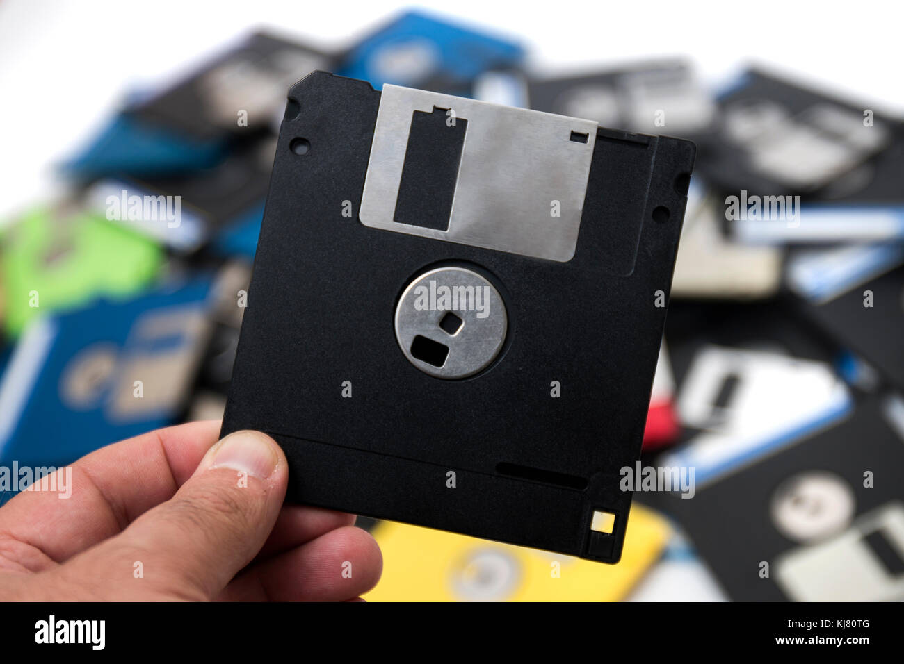 hand grabs a floppy disk from a big pile on the background Stock Photo ...