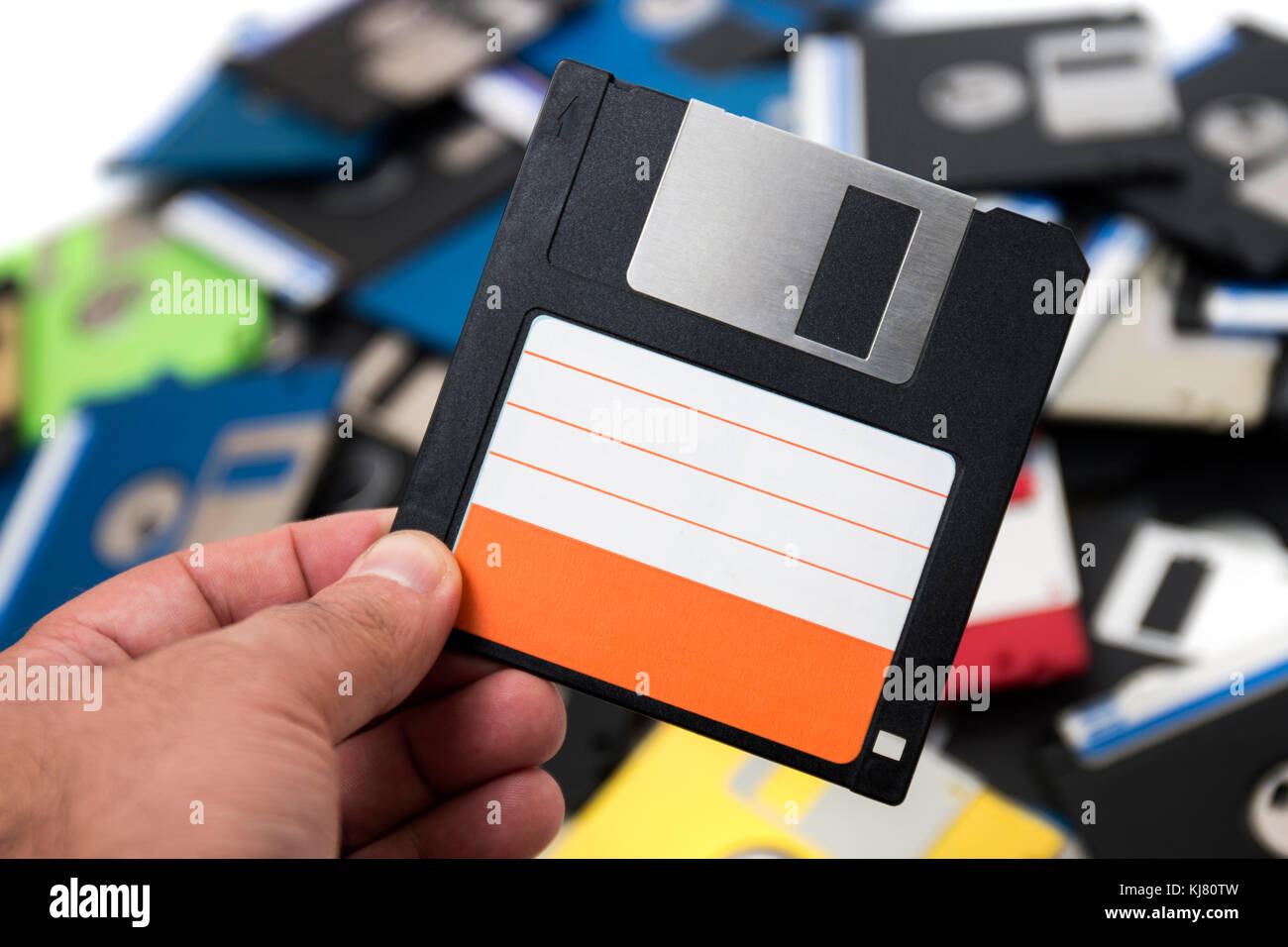 hand grabs a floppy disk from a big pile on the background Stock Photo ...