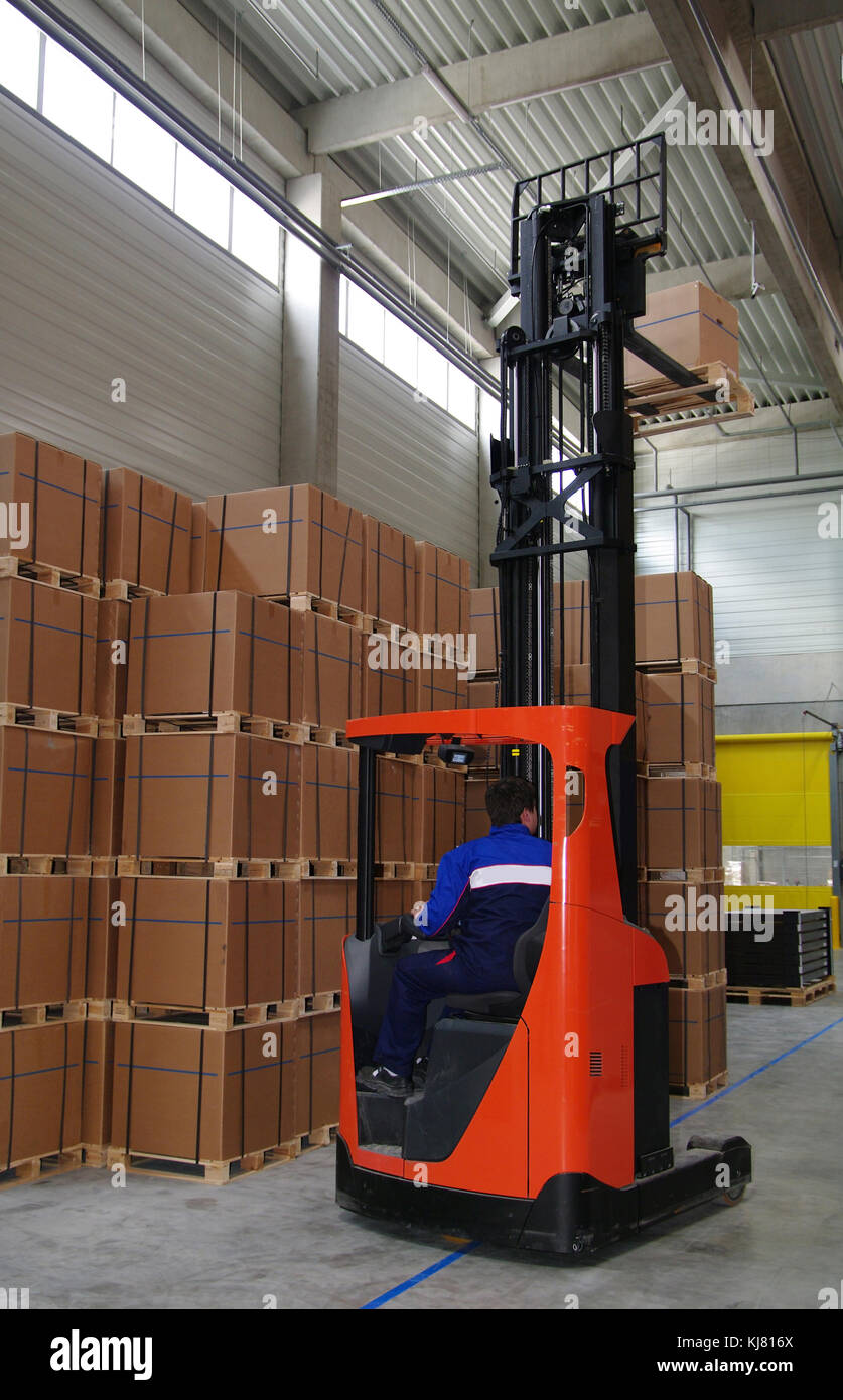Arrange warehouse with a forklift. Forklift moving pallets in warehouse ...