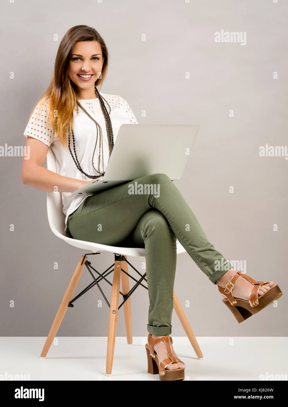 Beautiful woman sitting on a chair and working with a laptop Stock ...