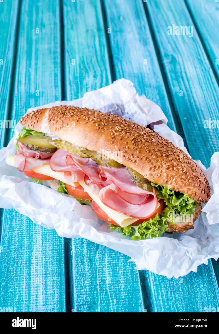 Served submarine sandwich stuffed with meat and cheese,selective focus ...