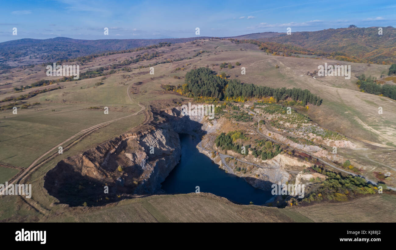 The emerald lake in old abandoned basalt quarry. Racos, Romania Stock ...
