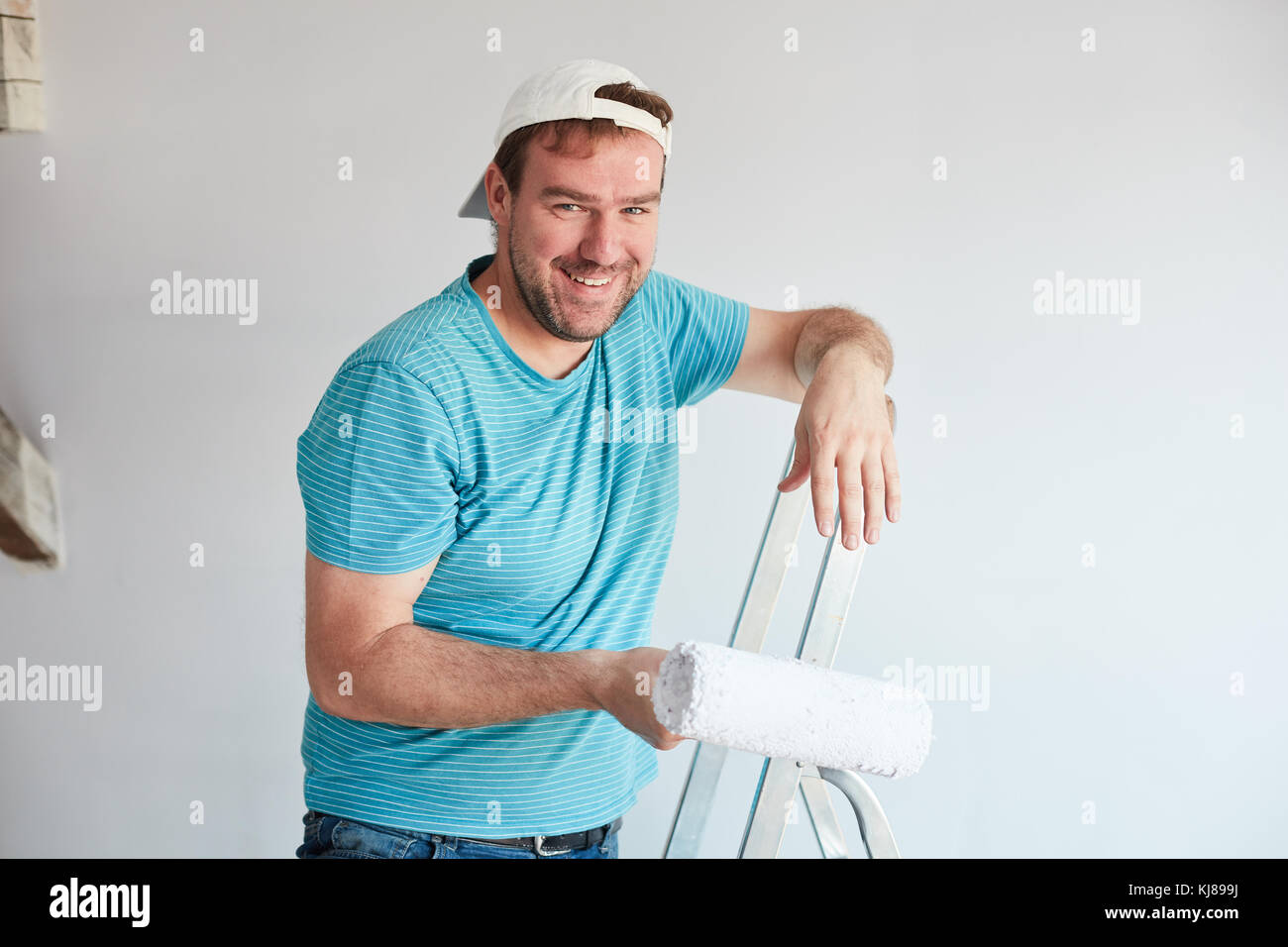 Smiling man holding a roller in front of him Stock Photo - Alamy